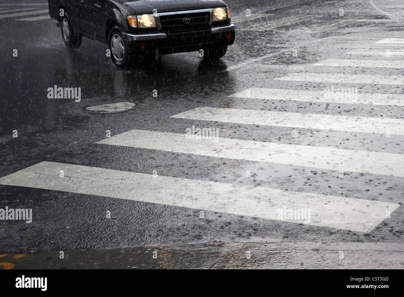 car approaching crosswalk in heavy rain downtown broadway Nashville ...