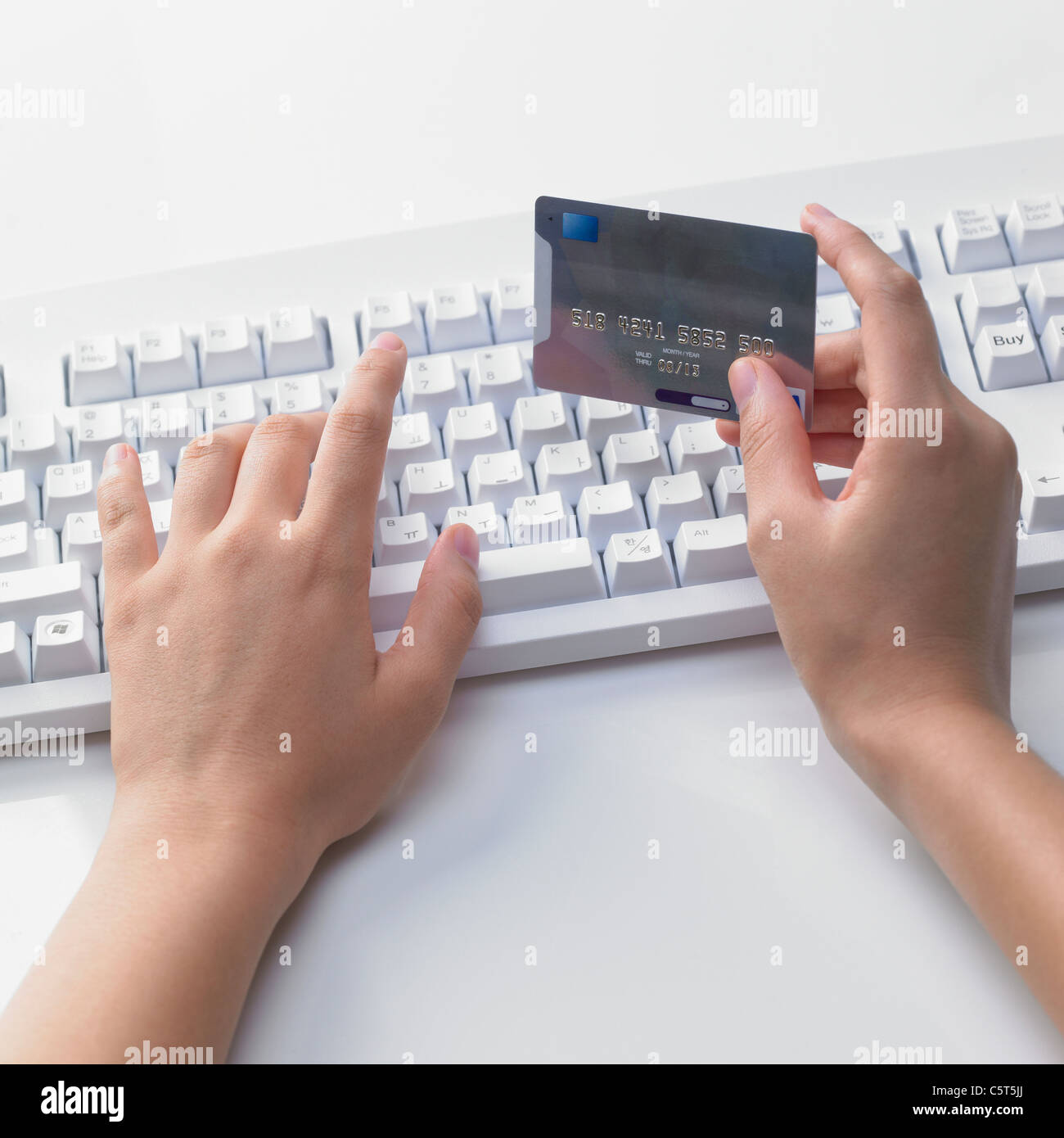 A person typing keyboard and holding a credit card Stock Photo - Alamy