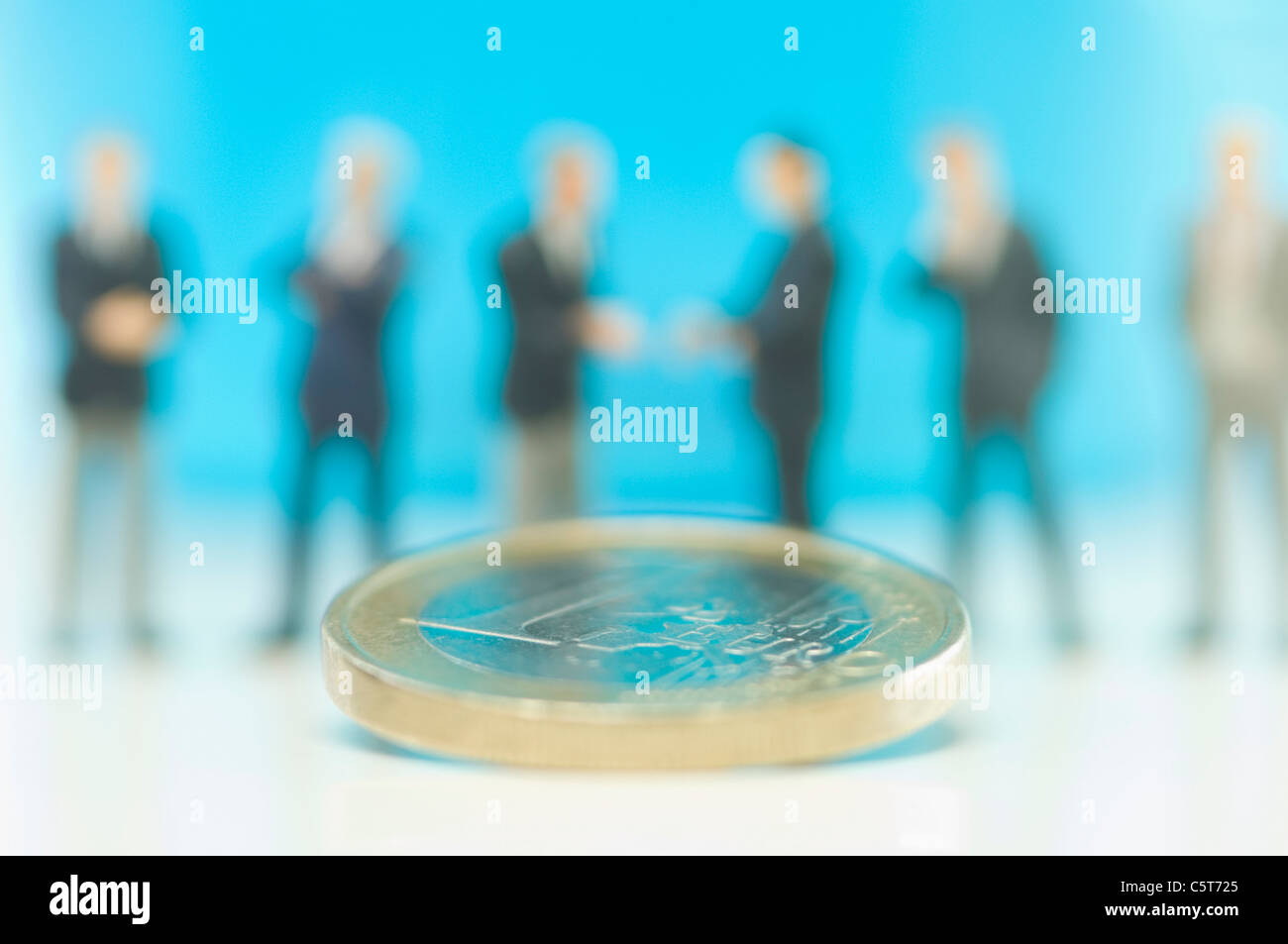 Coin with Shake hands figurines Stock Photo - Alamy