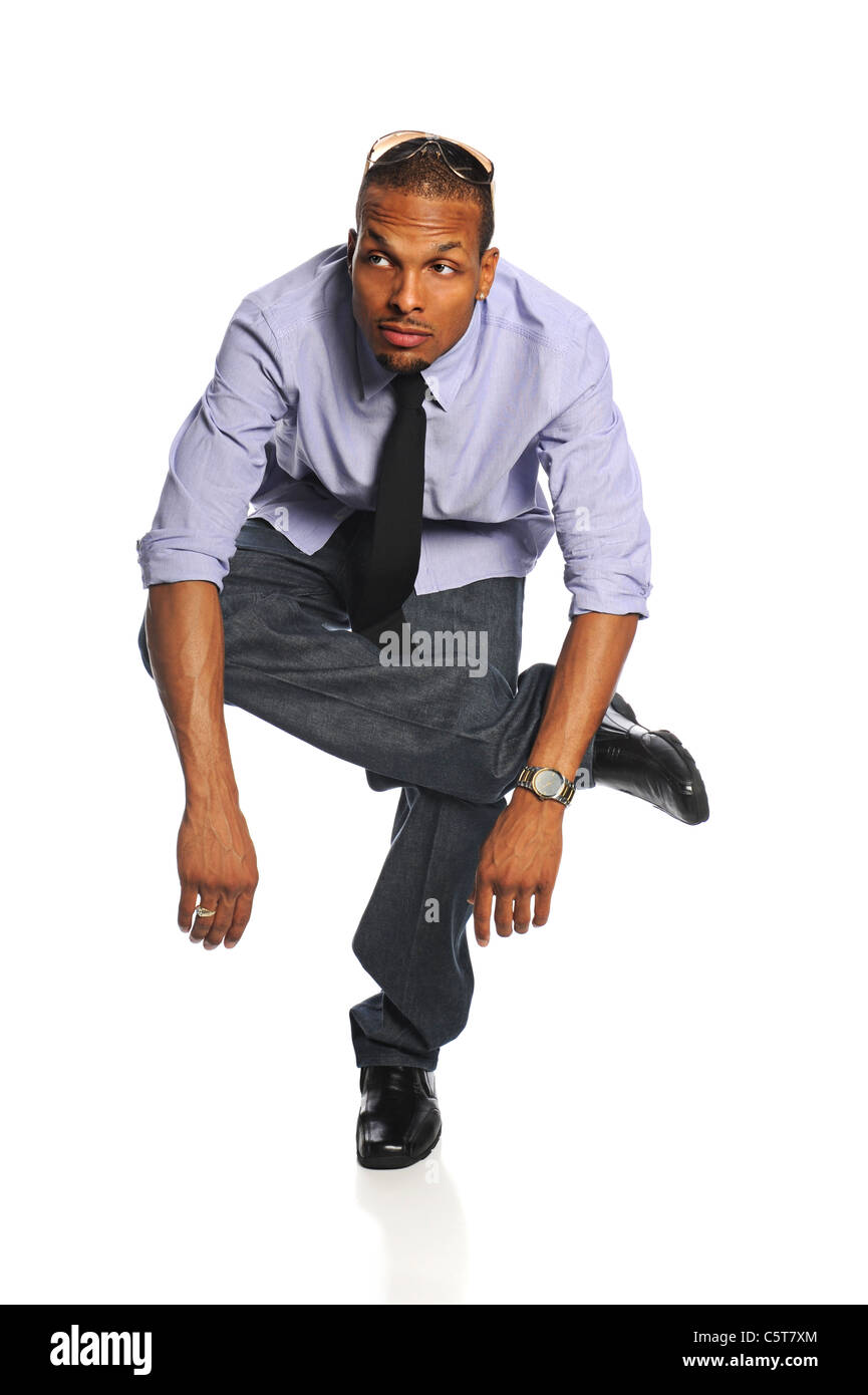 Portrait of African American businessman standing on one foot isolated ...