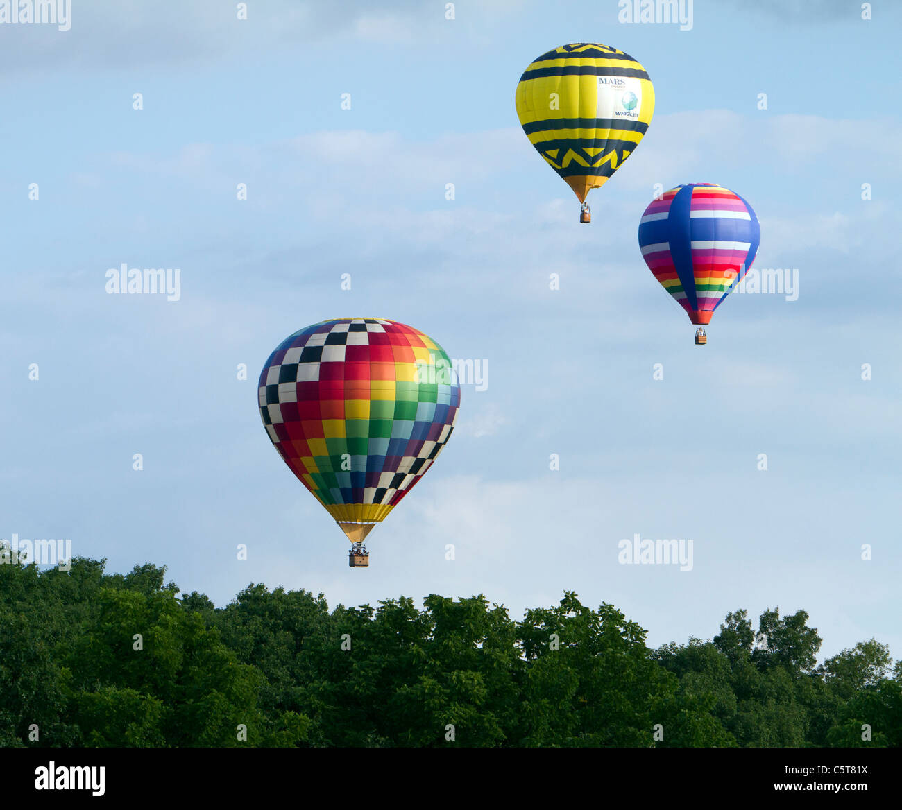 Three hot air balloons over trees Stock Photo - Alamy