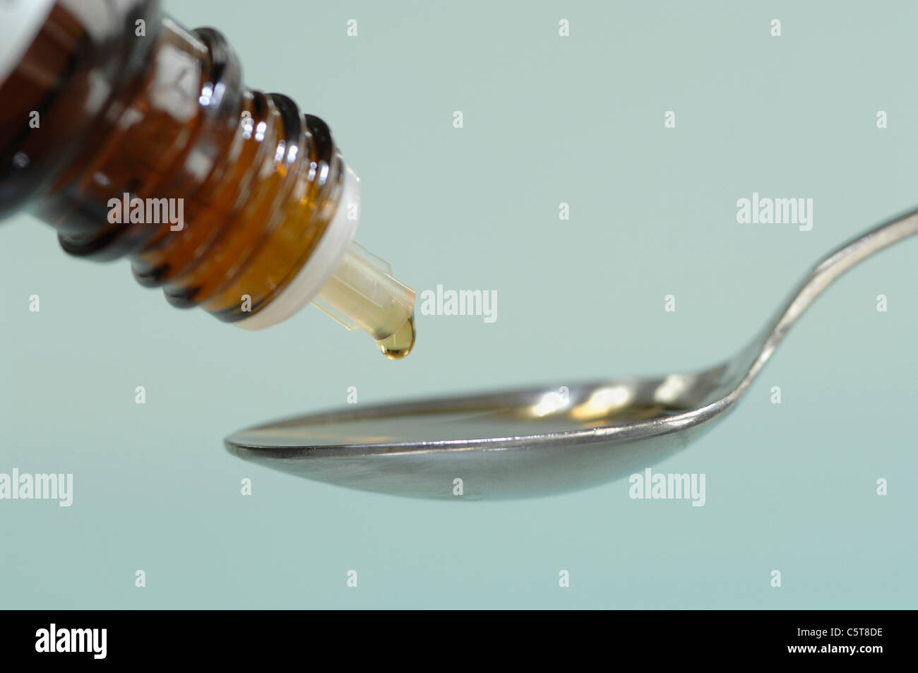 Medicine dropping onto spoon hi-res stock photography and images - Alamy