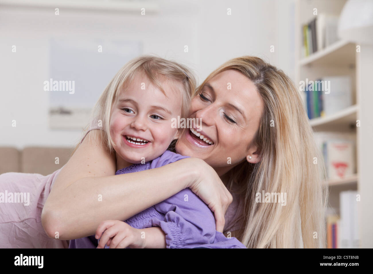 Germany, Bavaria, Munich, Mother embracing daughter, smiling Stock ...