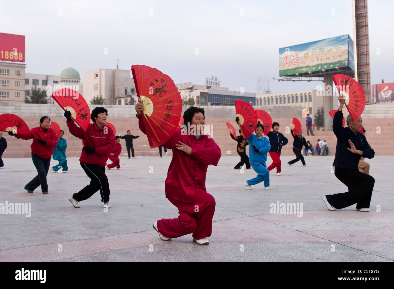 Han Chinese people exercise at dawn in the central square in Turpan ...