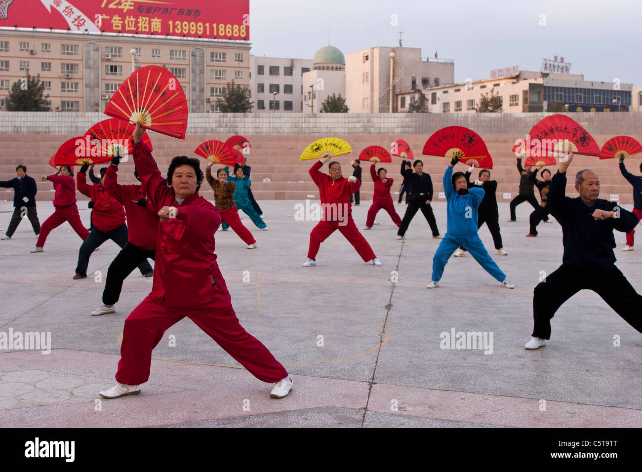 Han Chinese people exercise at dawn in the central square in Turpan ...