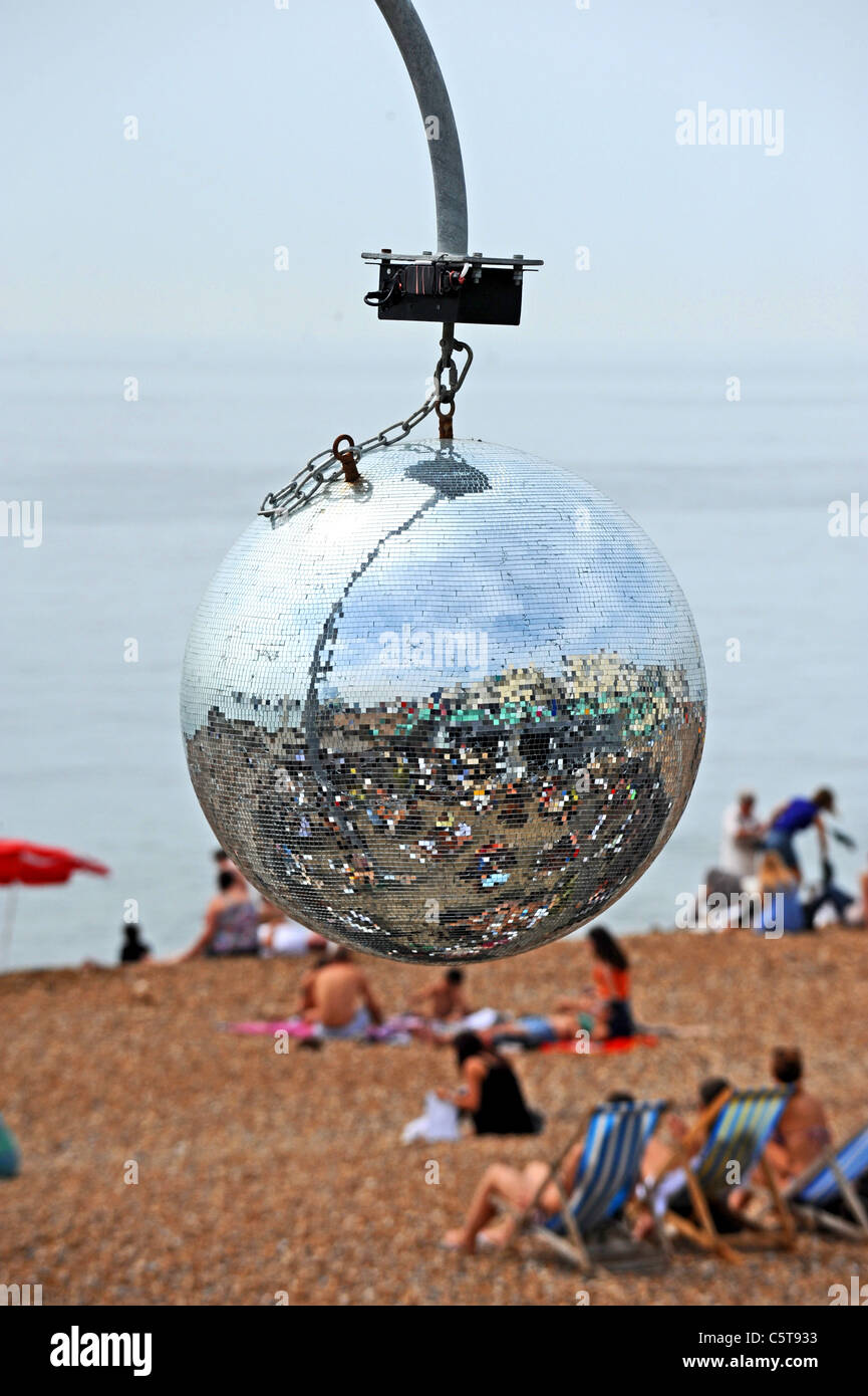 Large reflective silver ball hanging from a bar beside Brighton beach ...