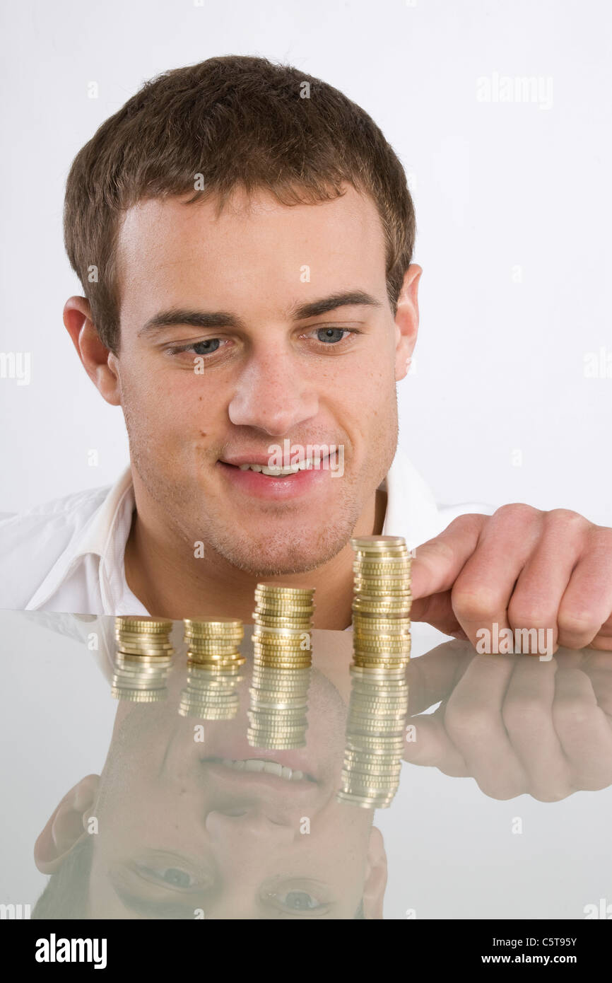 Young man counting Euro coins, portrait Stock Photo - Alamy