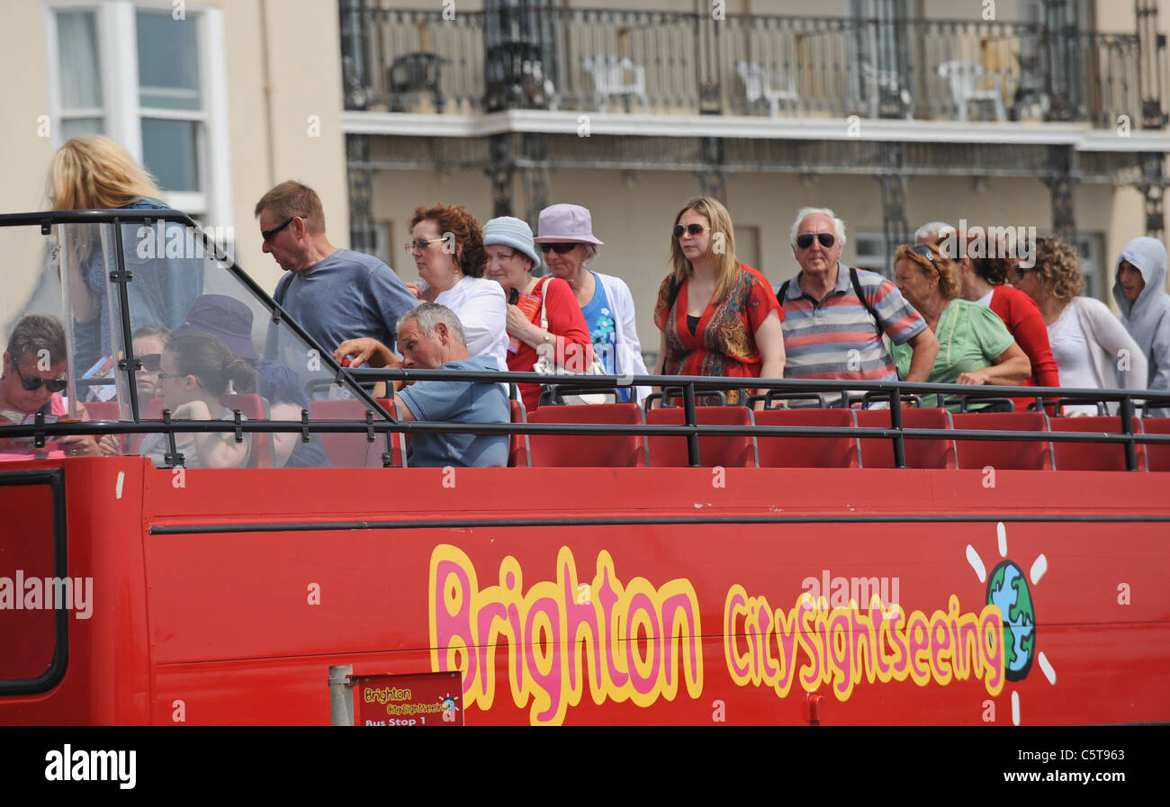 Tourists enjoy the hot weather and a trip out on an open top Brighton ...