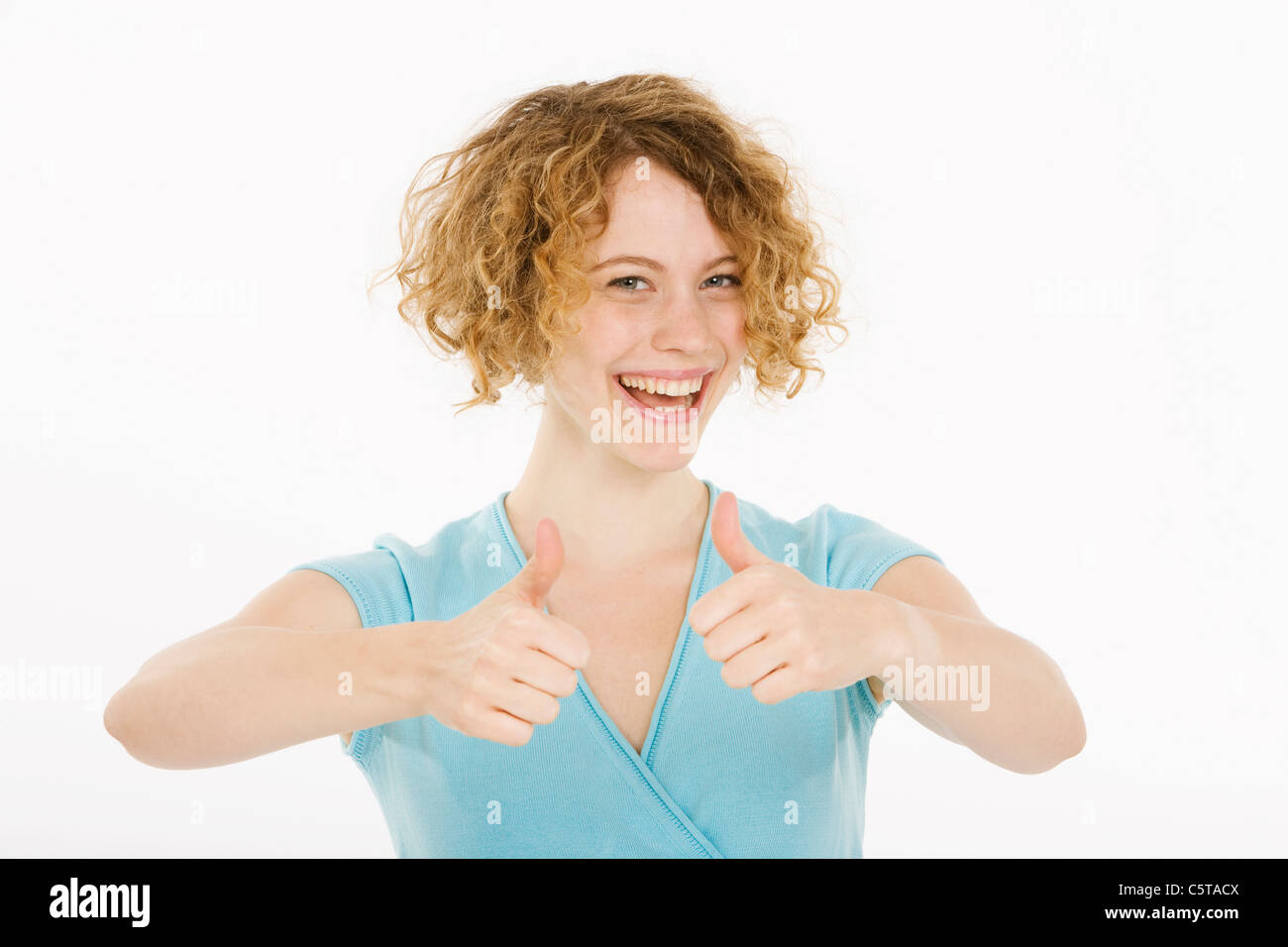 Young woman smiling, thumbs up, portrait Stock Photo - Alamy