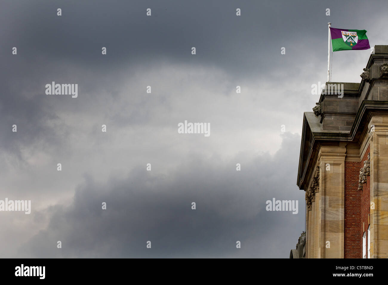 Coat of arms flag flapping in grey skies above James Graham Building ...
