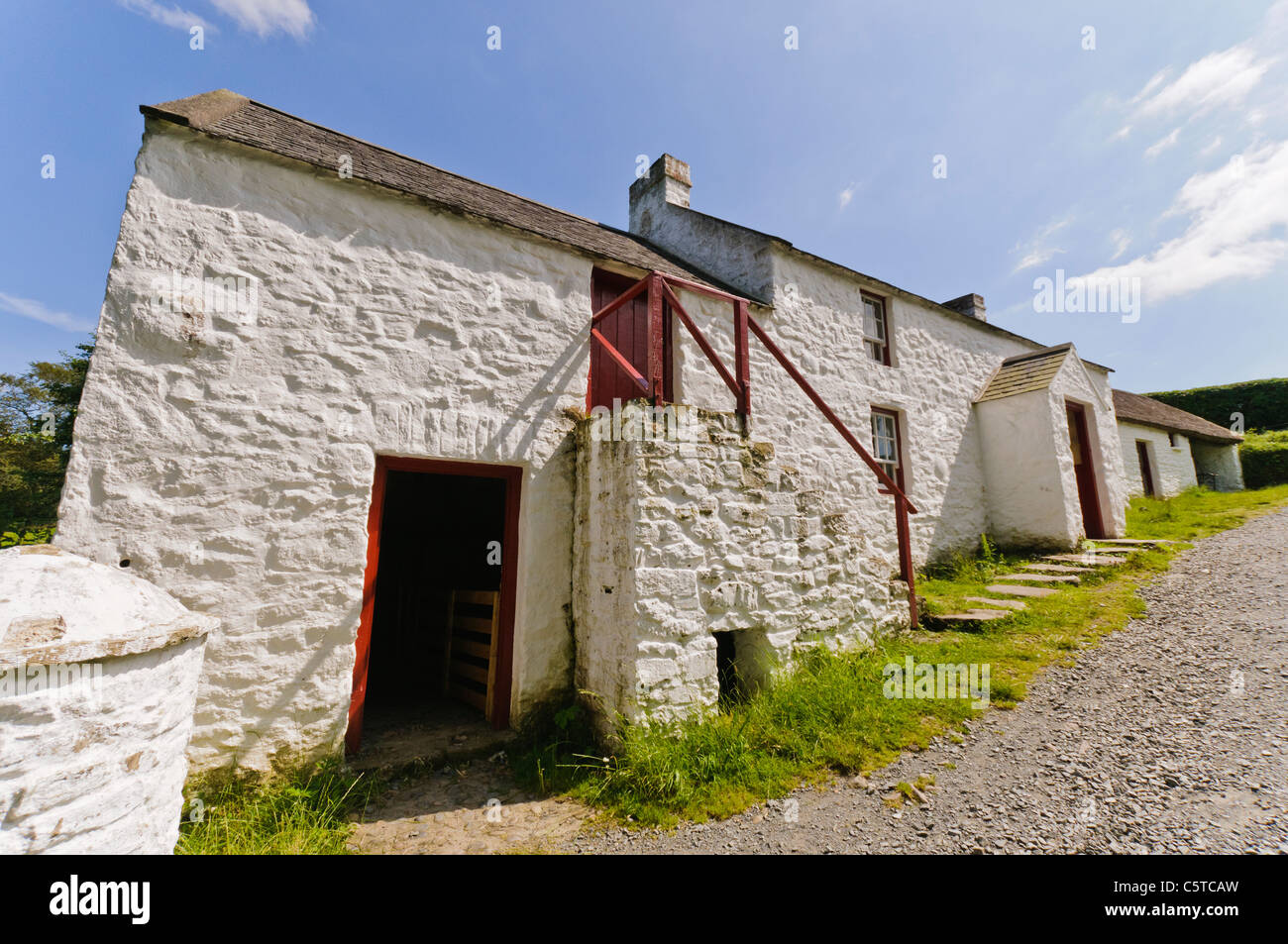 Traditional Irish whitewashed farmhouse built on a hill at the Ulster ...
