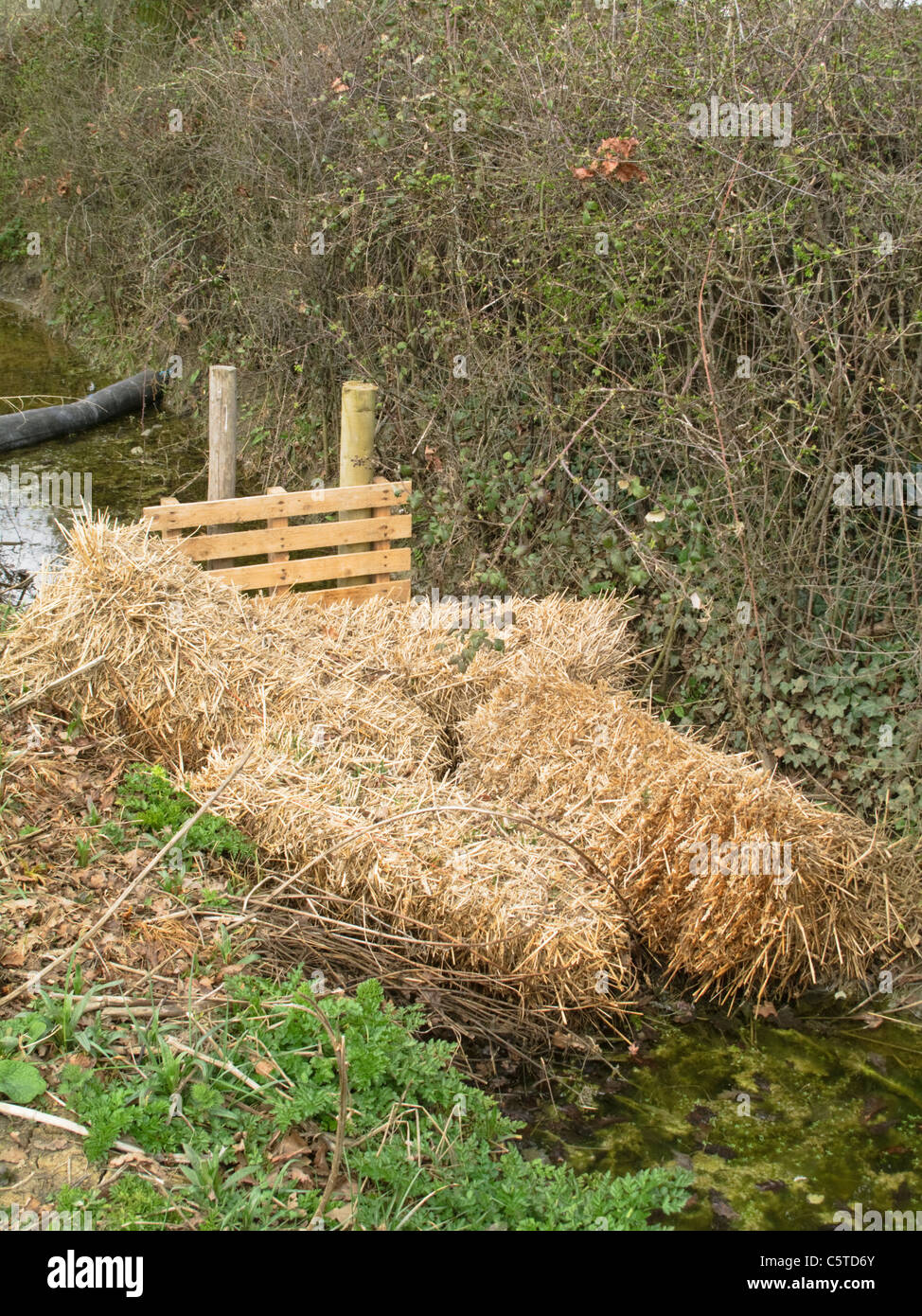 Floating containment barrier and bales of straw being used to clean up ...