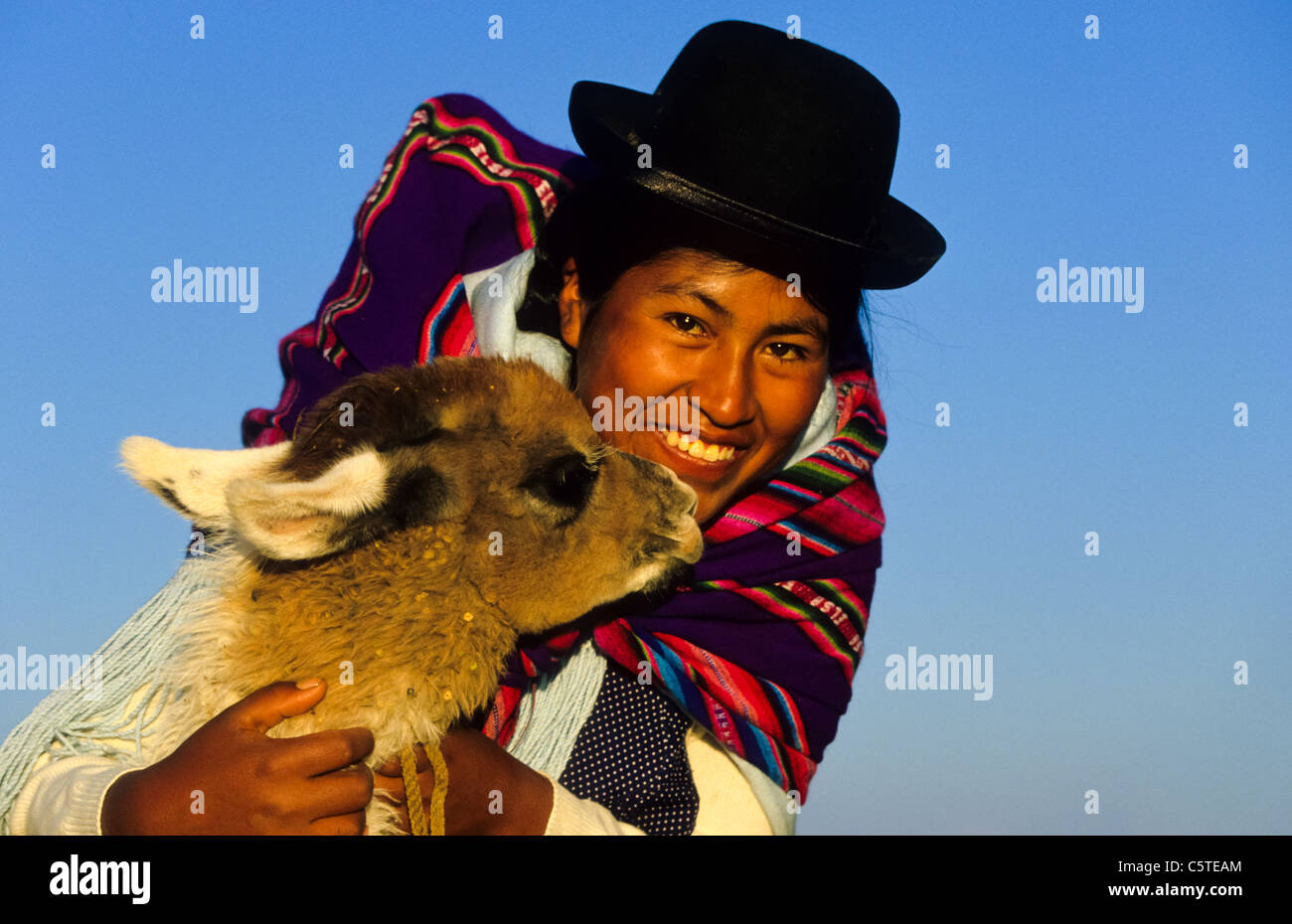 Portrait of young inka woman with lama bay in the sunrise on Isla del ...