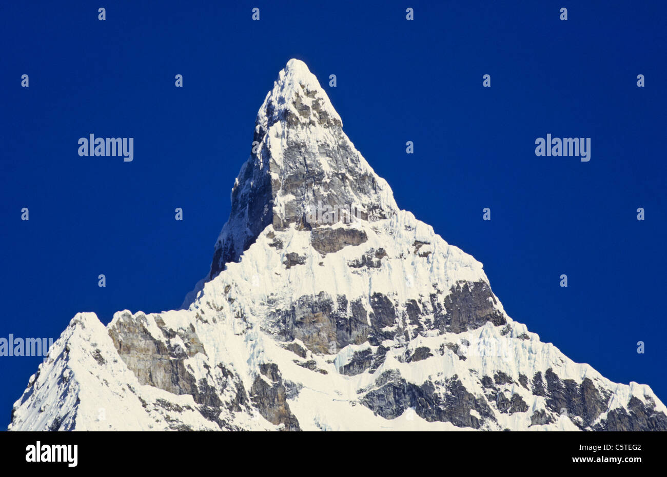 A close up of a perfect snow covered pyramid peak in Cordillera Blanca ...
