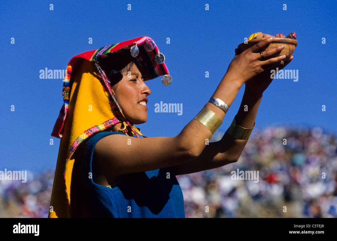 Inka woman with yellow head dress holding offering up to the sun good ...