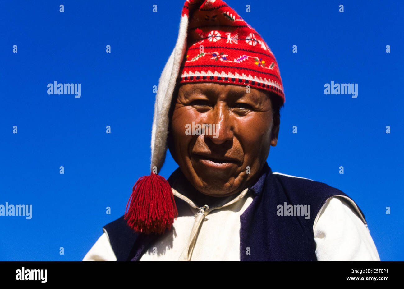 Indian man with self knitted hat against the blue sky. Smiling portrait ...