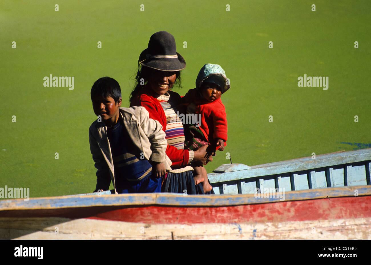 Inka mother with two children in a rowboat on Titicaca Lake full of ...