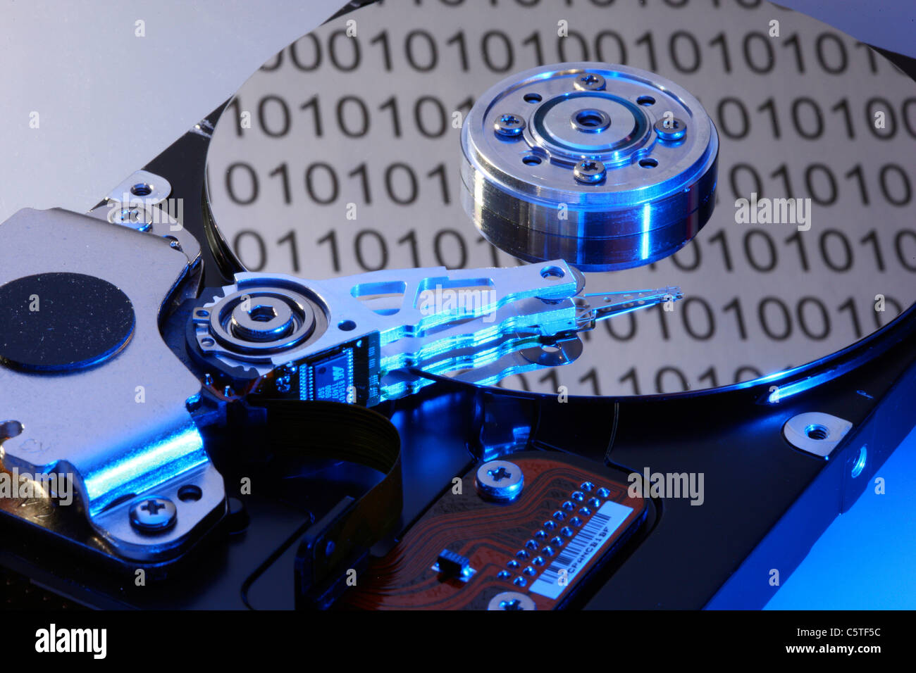 Computer hard drive, opened, writing/reading head and hard disk. Binary ...