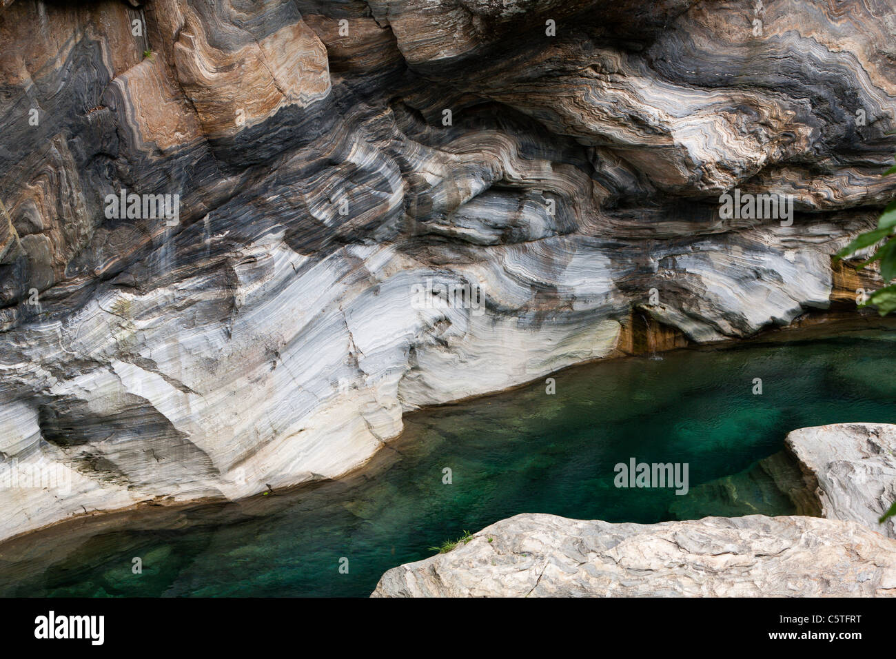 A crystal clear stream flows through marble canyons, beautiful folded ...