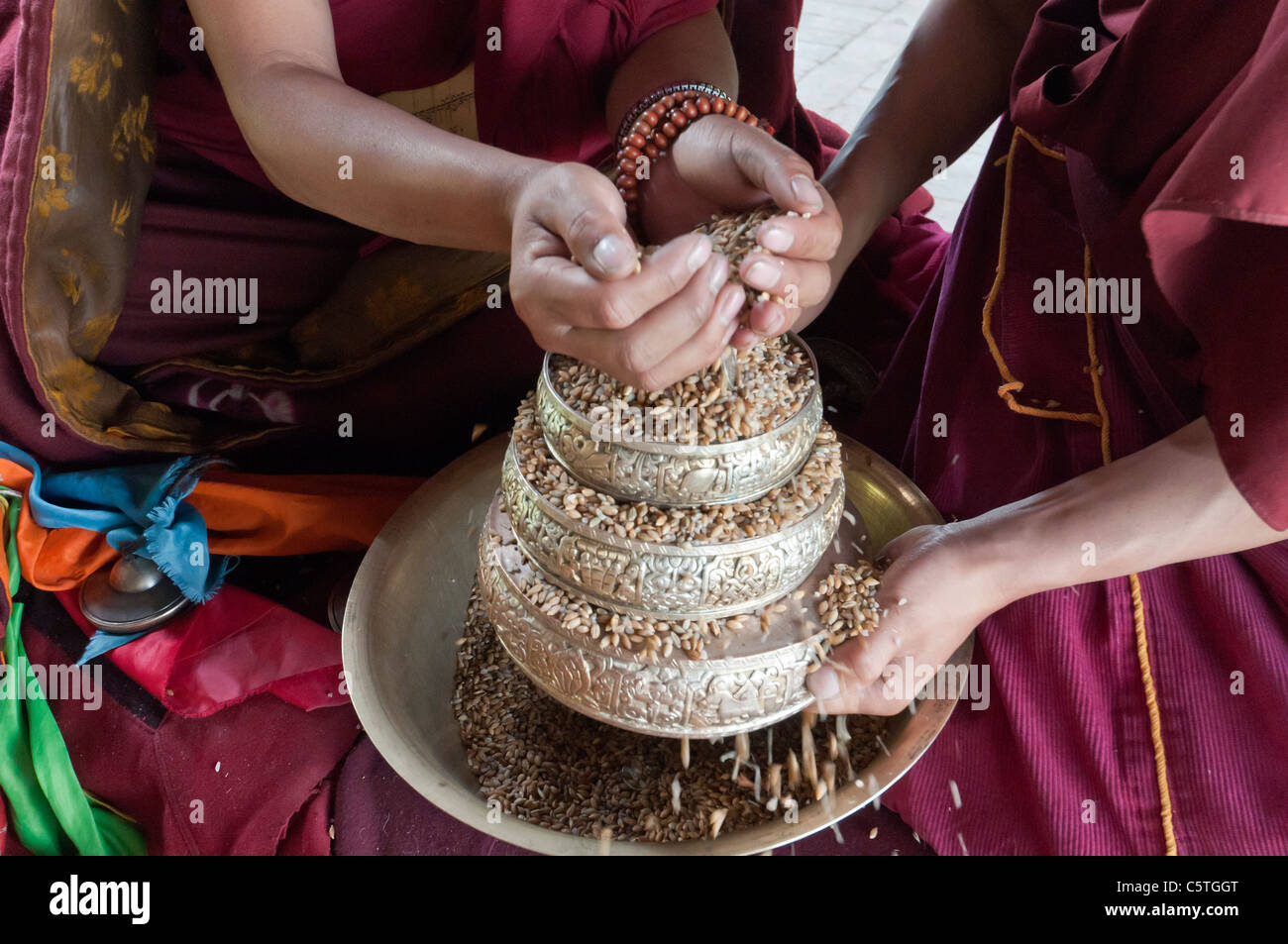 Tibetan Buddhist monks perform ritual with rice and silver rings, Arou ...