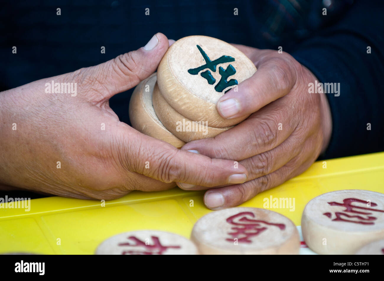 Player holds game pieces during Xiangqi, or Chinese chess, at outdoor ...