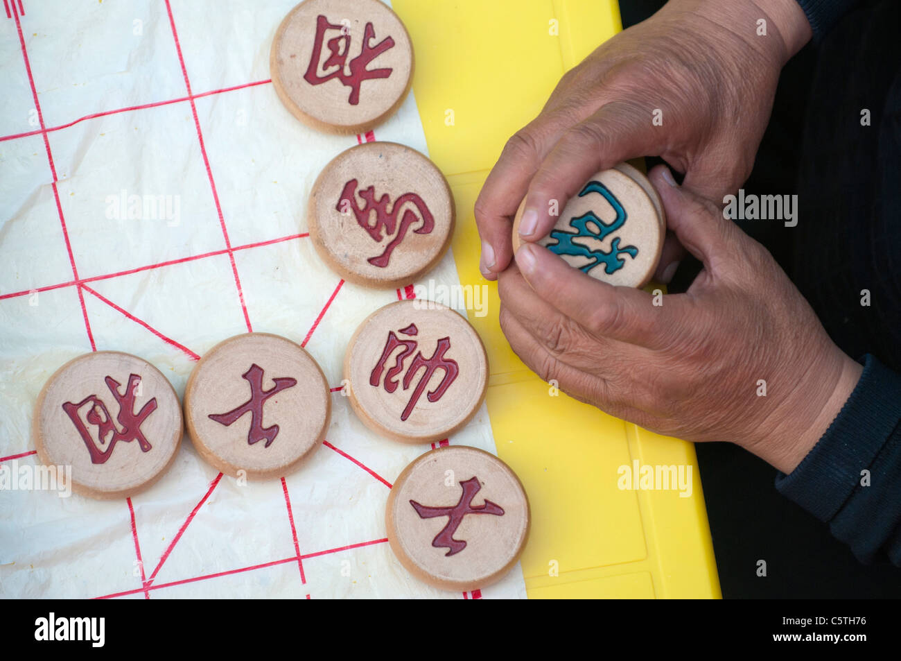 Player holds game pieces during Xiangqi, or Chinese chess, at outdoor ...