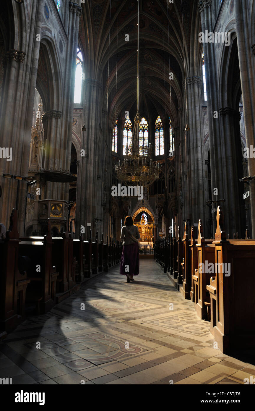 Young woman standing in church, rear view, Votive Church, Vienna ...