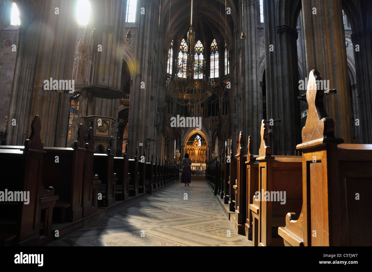 Young woman standing in church, rear view, Votive Church, Vienna ...