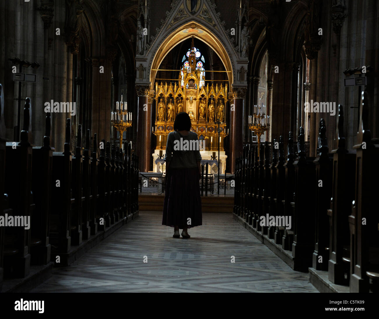 Young woman standing in church, rear view, Votive Church, Vienna ...