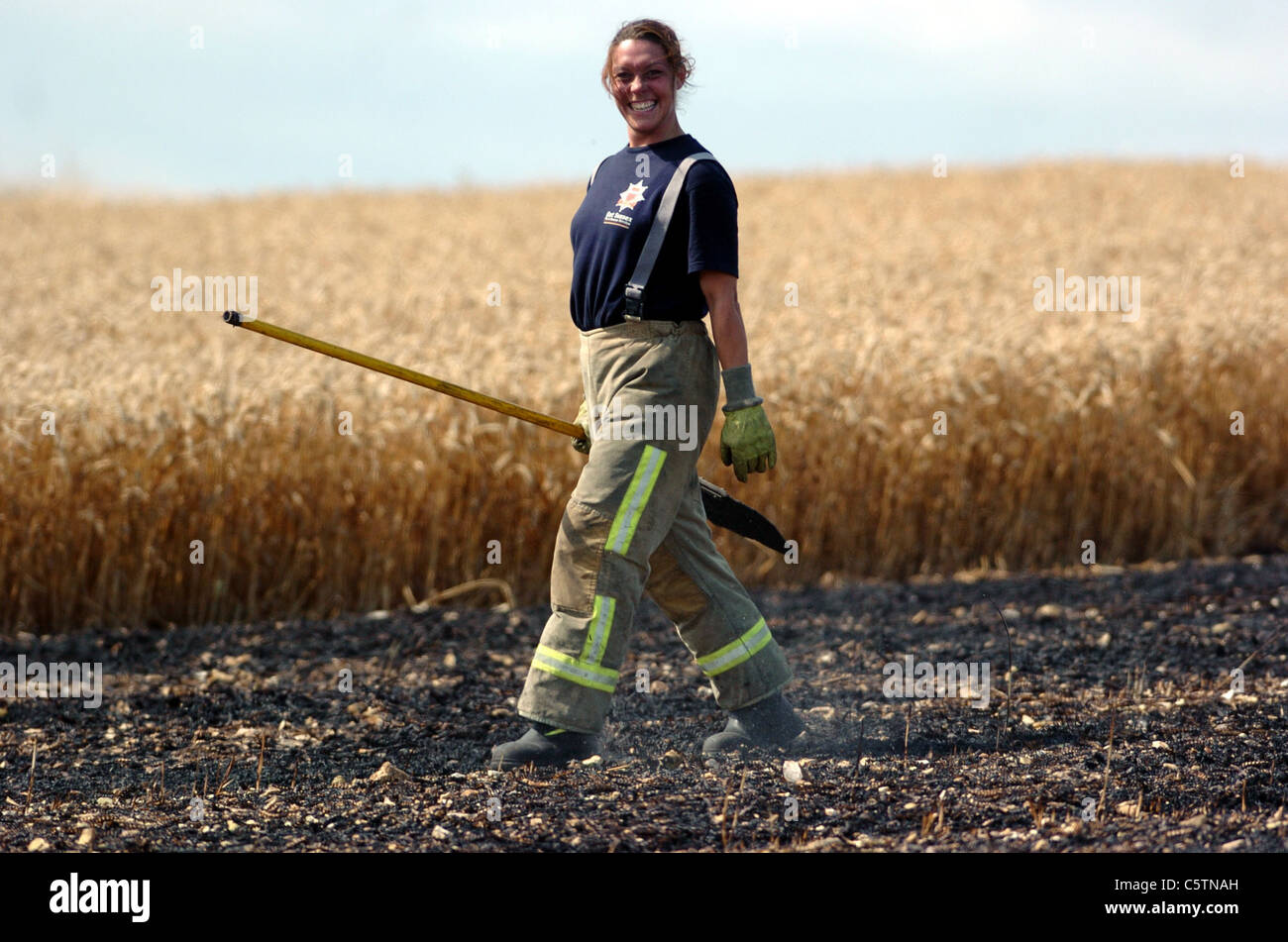 Female member of the Fire Brigade makes her way back across charred ...