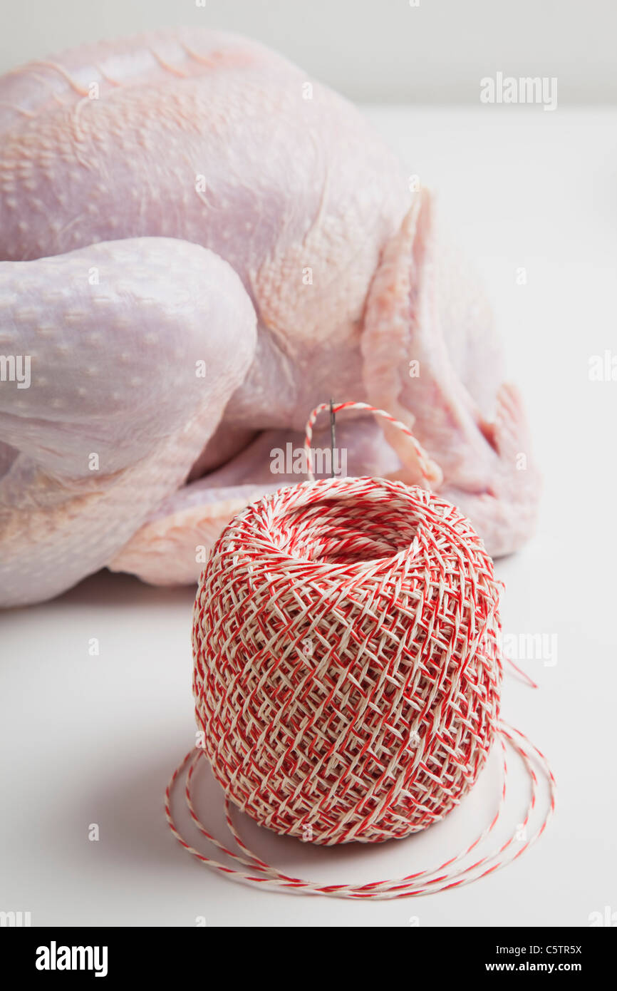 kitchen cooking yarn wtih needle and raw turkey Stock Photo - Alamy