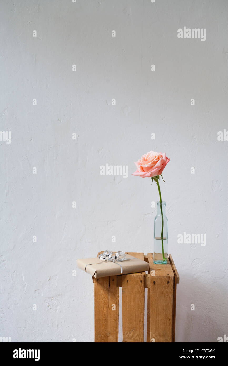 Gift parcel and rose on wooden box Stock Photo - Alamy