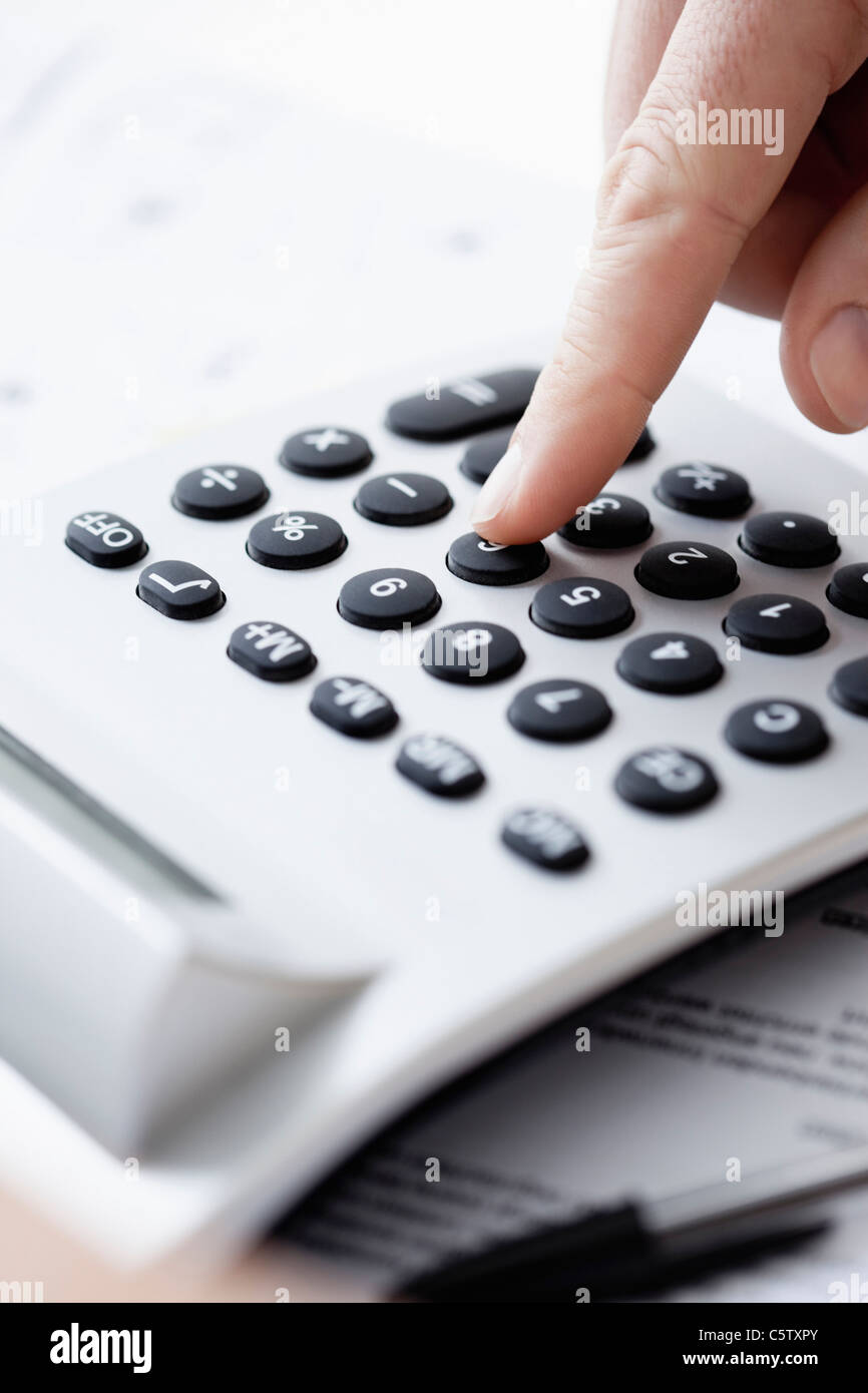 Person's finger operating a calculator Stock Photo - Alamy