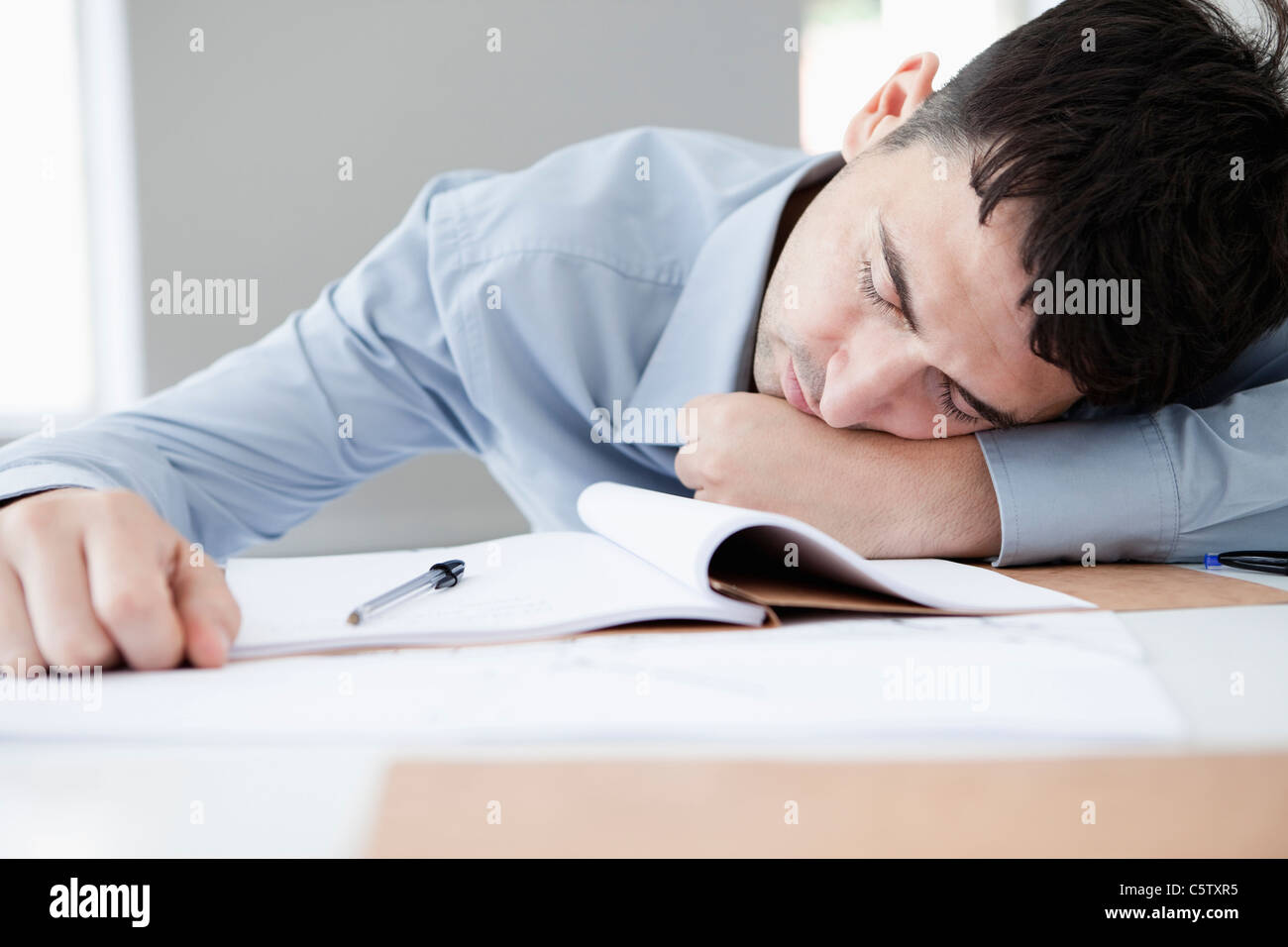 Businessman in office sleeping at workplace Stock Photo - Alamy