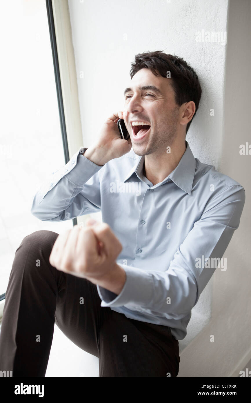 Businessman using mobile phone, rejoicing, portrait Stock Photo - Alamy