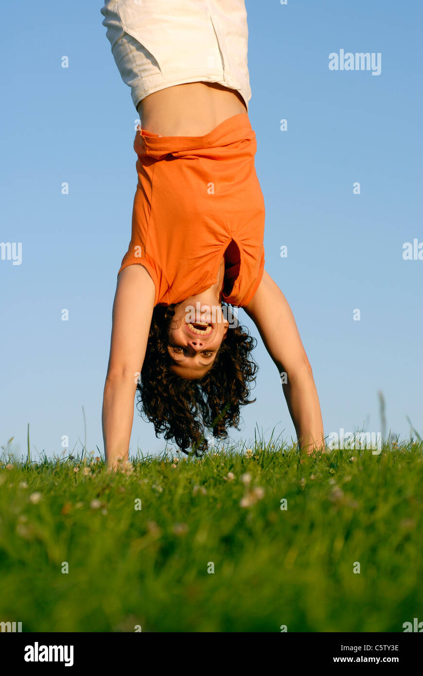 Young woman doing handstand on meadow Stock Photo - Alamy