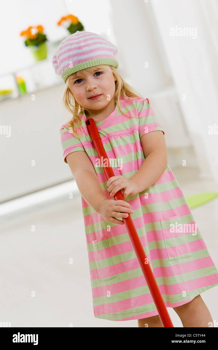 Little girl (4-5) playing with broom Stock Photo - Alamy