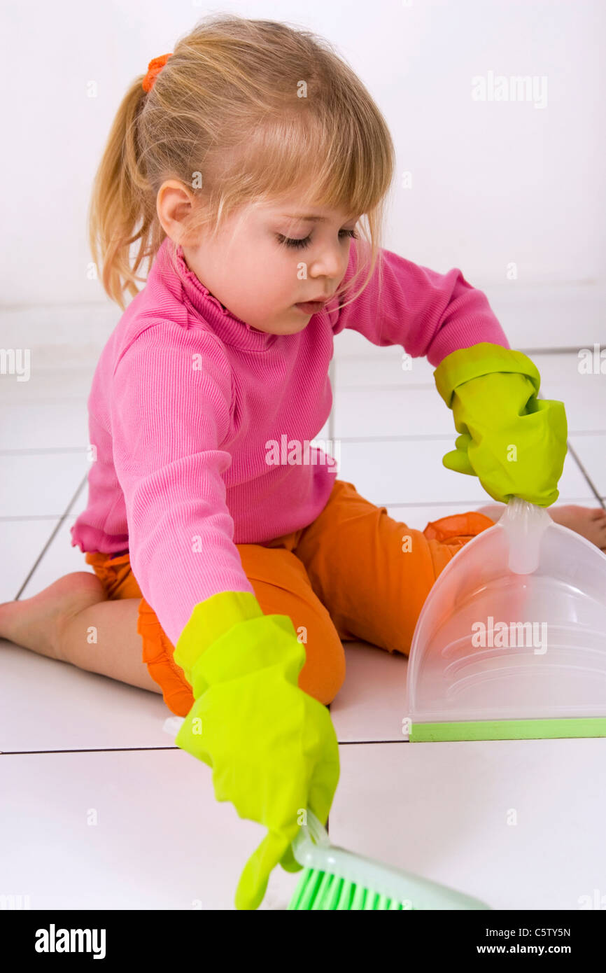 Little girl (4-5) playing with hand broom and dust pan Stock Photo - Alamy