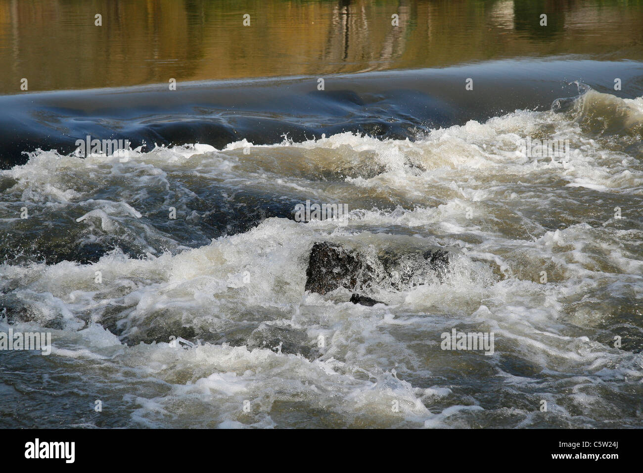 A river flows over a stone ford , river "La Varenne" (Orne, Normandy ...