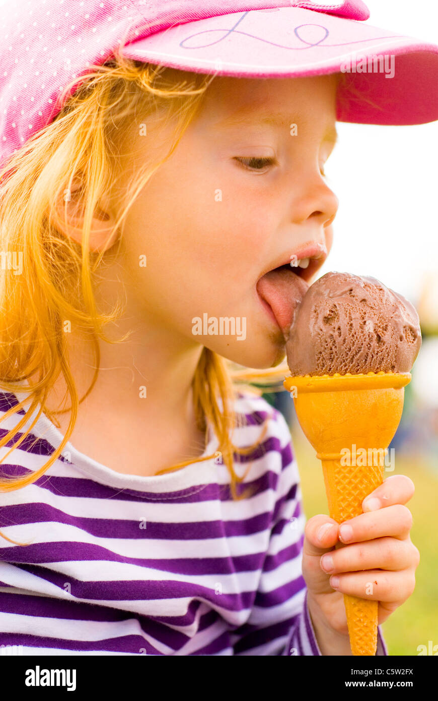 Girl licking a chocolate ice cream Stock Photo - Alamy