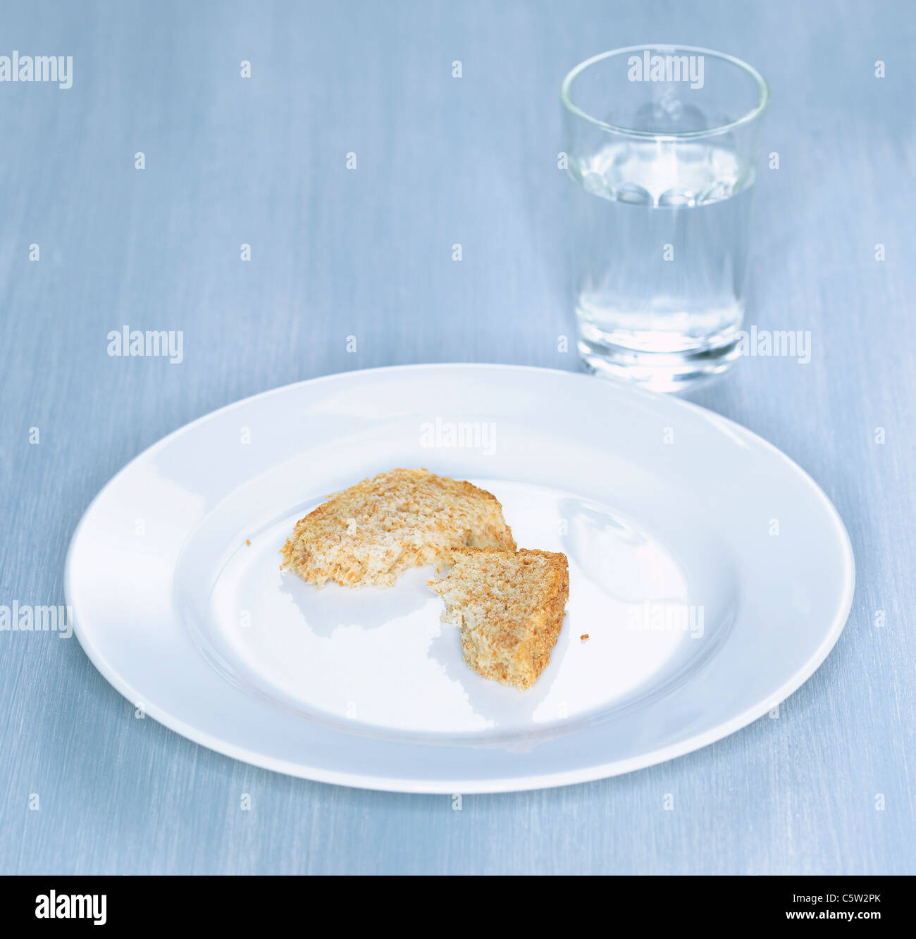 Bitten whole meal toast on plate, in background glass of water Stock ...