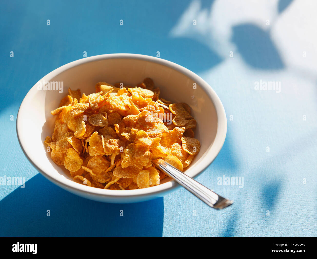 Cornflakes and spoon in bowl, close-up Stock Photo - Alamy