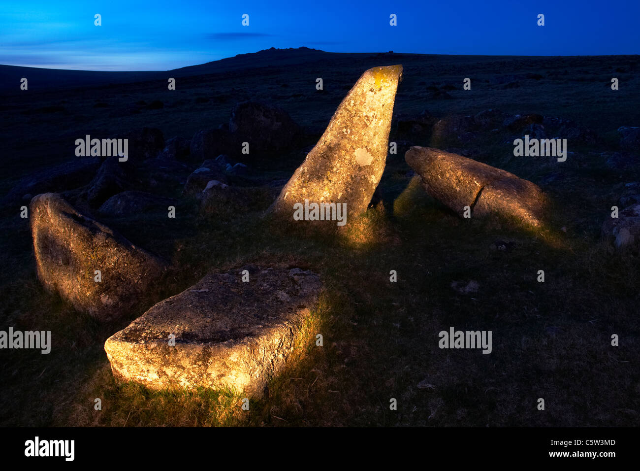 Remnants of a hut circle lit by torchlight at Merrivale settlement on ...