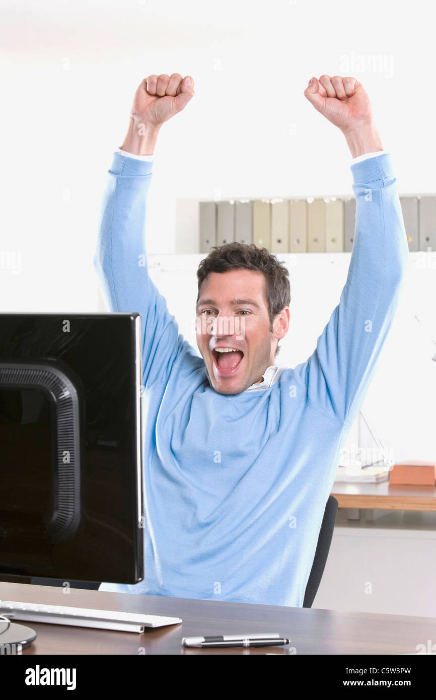 Germany, Munich, business man in office, cheering, portrait Stock Photo ...