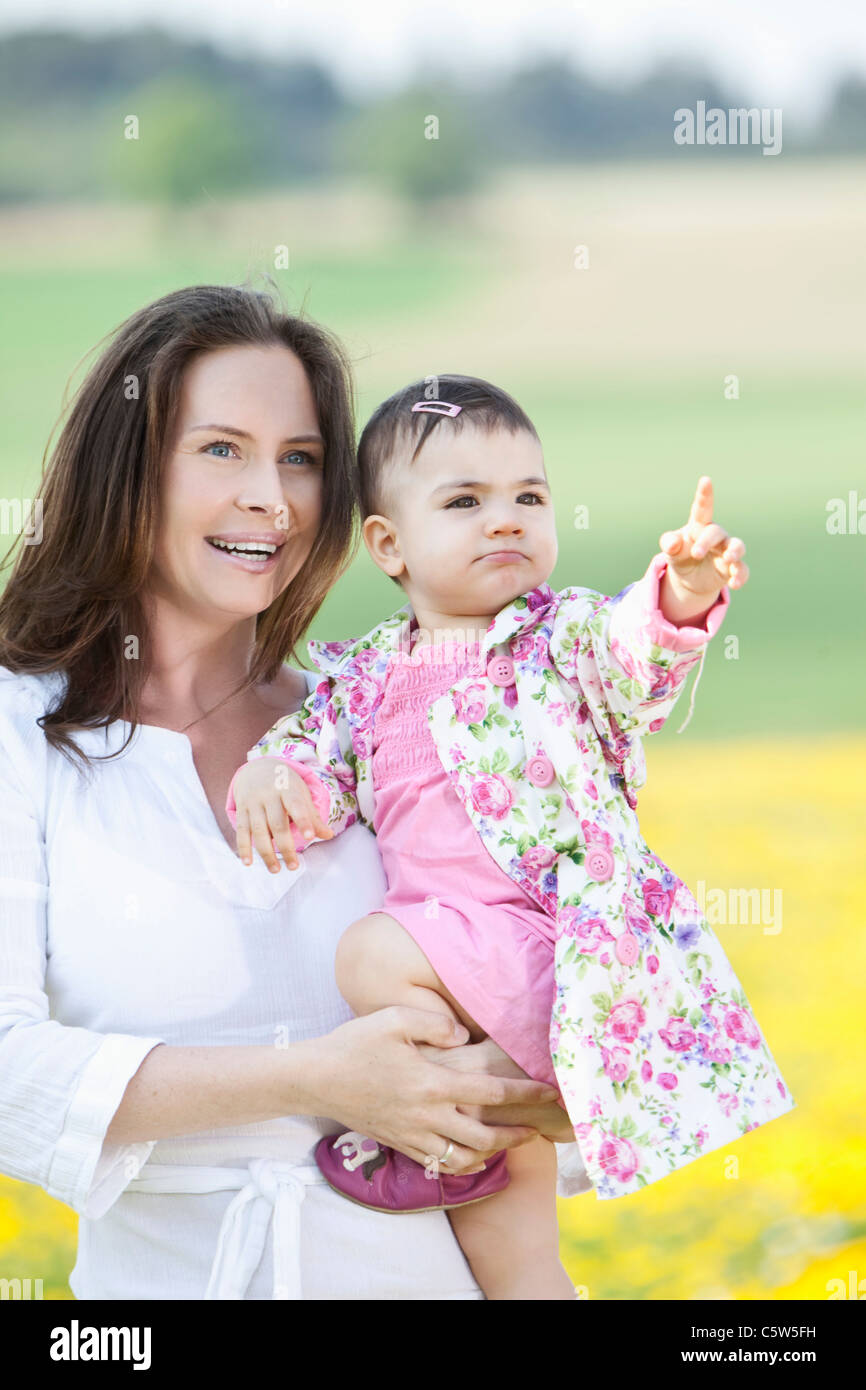 Germany, Bavaria, Mother holding her baby girl, smiling, pointing Stock ...