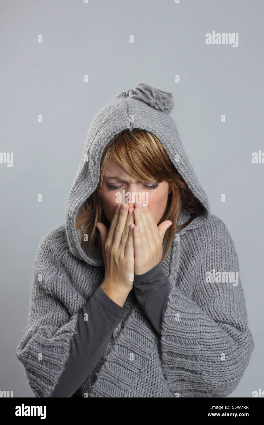 Woman sneezing looking down, portrait Stock Photo - Alamy