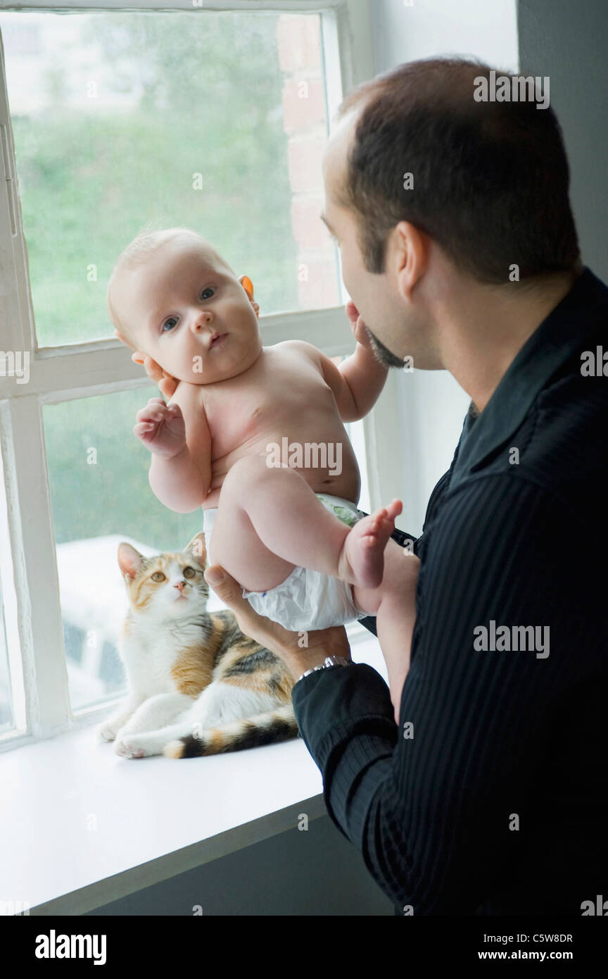 Father by window holding baby boy (6-11 months Stock Photo - Alamy