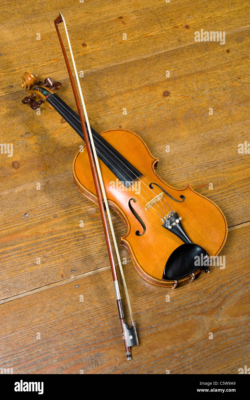 Violin and bow on wooden floor, elevated view Stock Photo - Alamy