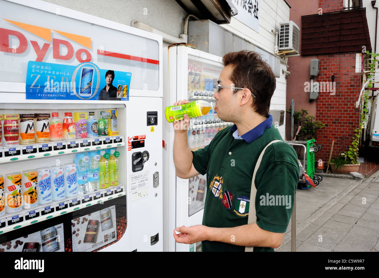Japan, Japanese man drinking a refreshment at a vending machine Stock ...