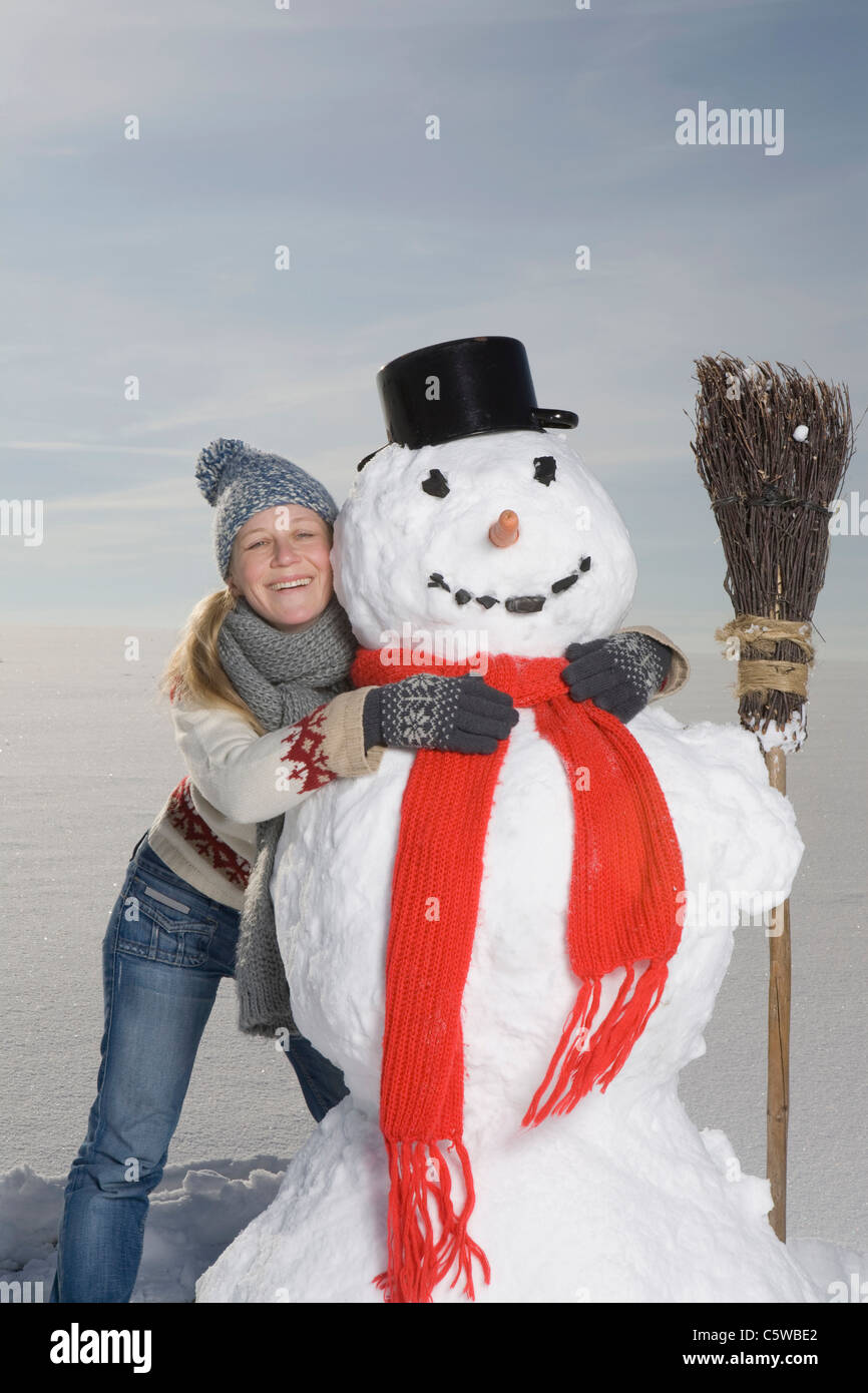 Germany, Bavaria, Munich, Woman hugging snowman Stock Photo - Alamy